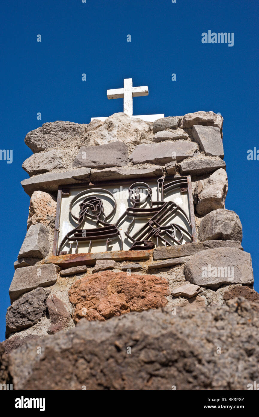 Under a blue sky stands one of the stone Stations of the Cross, Santo ...