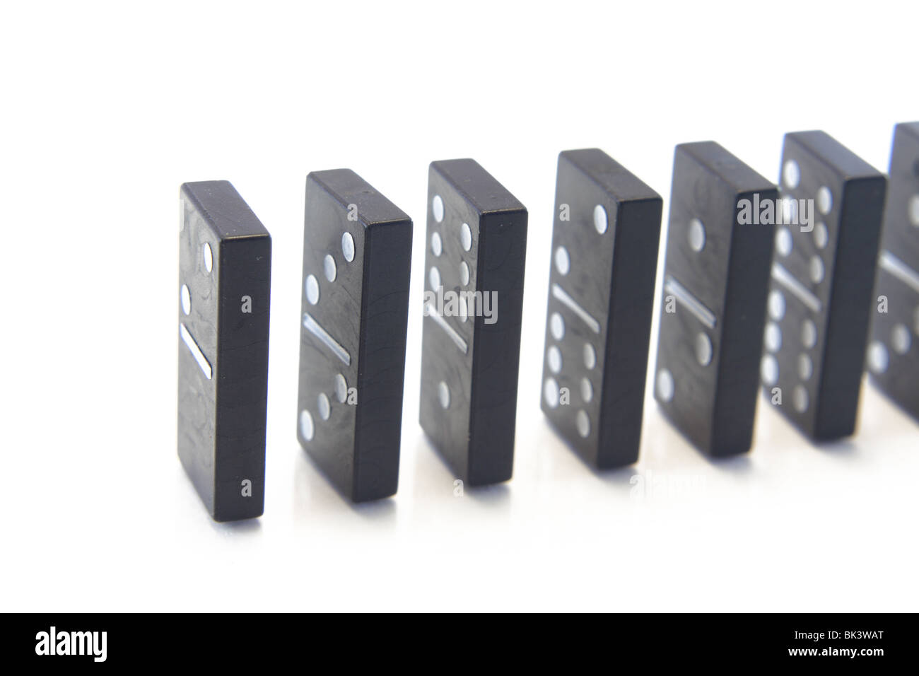 line of four domino with focus on first Stock Photo - Alamy