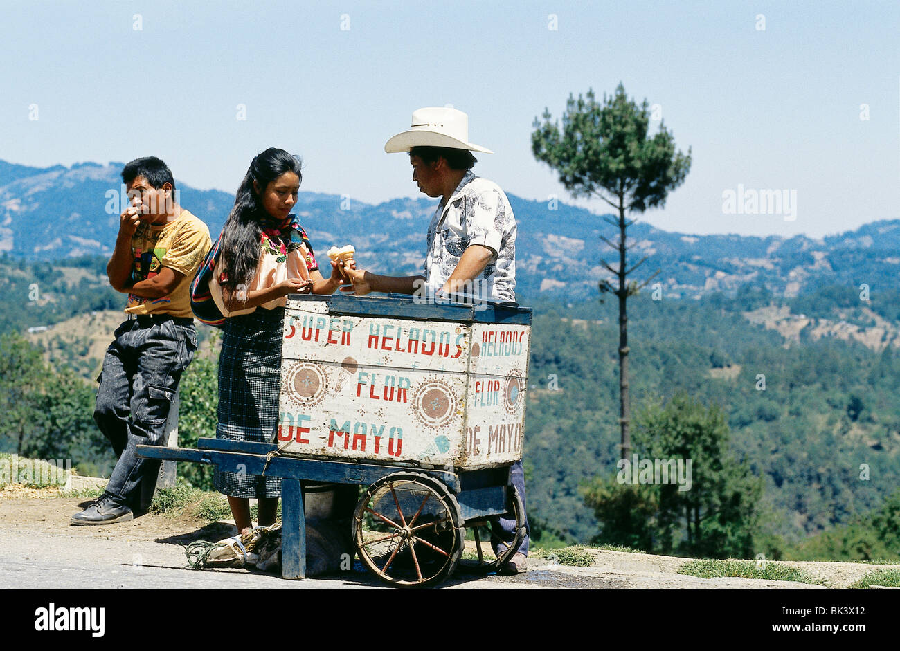 Ice cream vendor selling ice cream cones to customers from his homemade ...