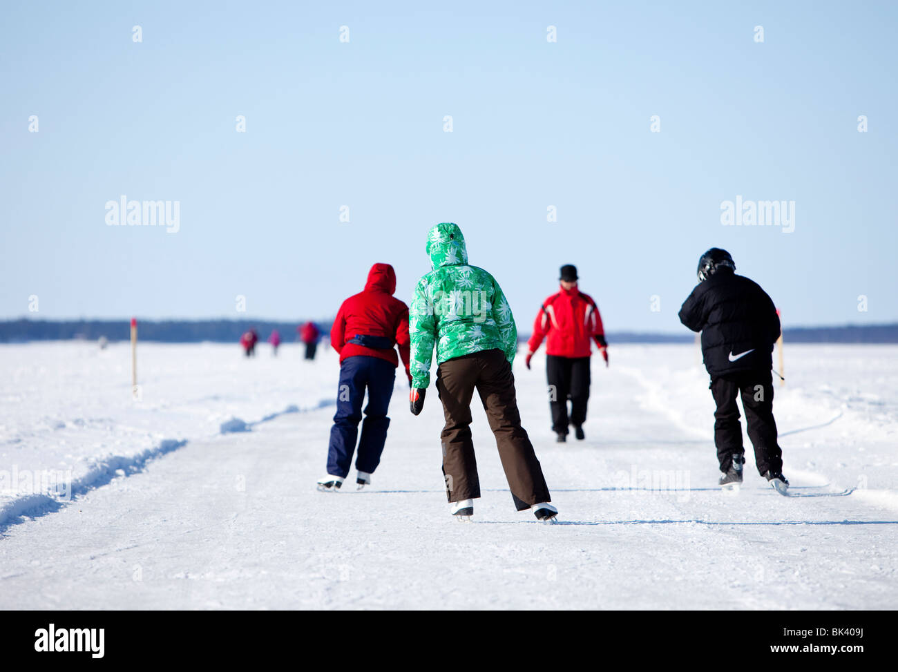 Group of skaters skating on a tour skating track made on sea ice ...