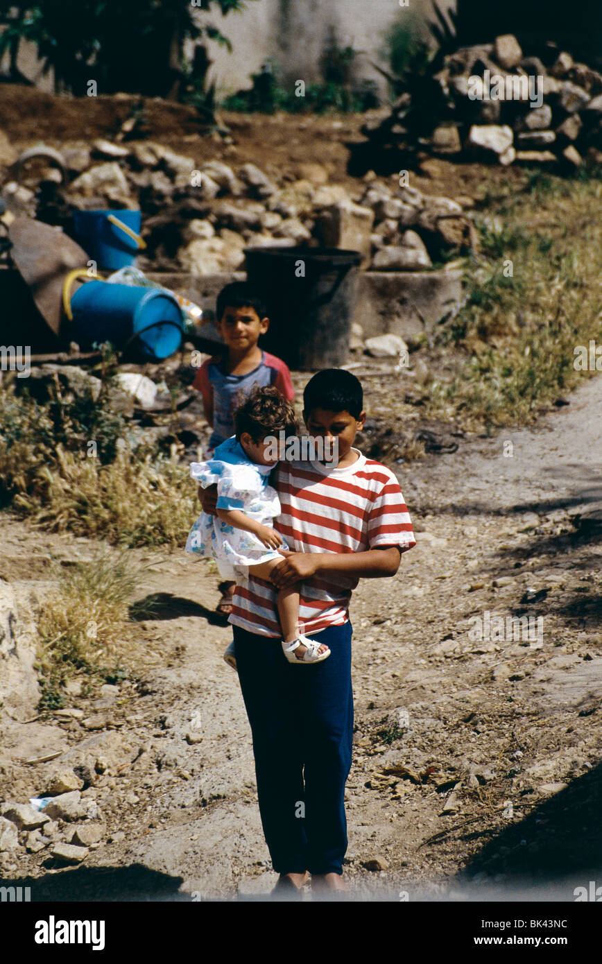 Young boy carrying a child in a white dress, Israel Stock Photo - Alamy