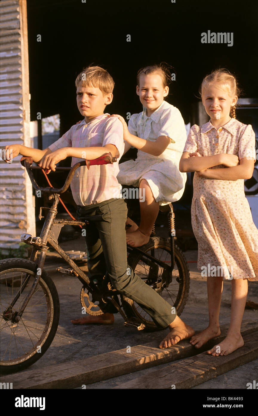 Three Amish children with a bicycle, Belize Stock Photo - Alamy