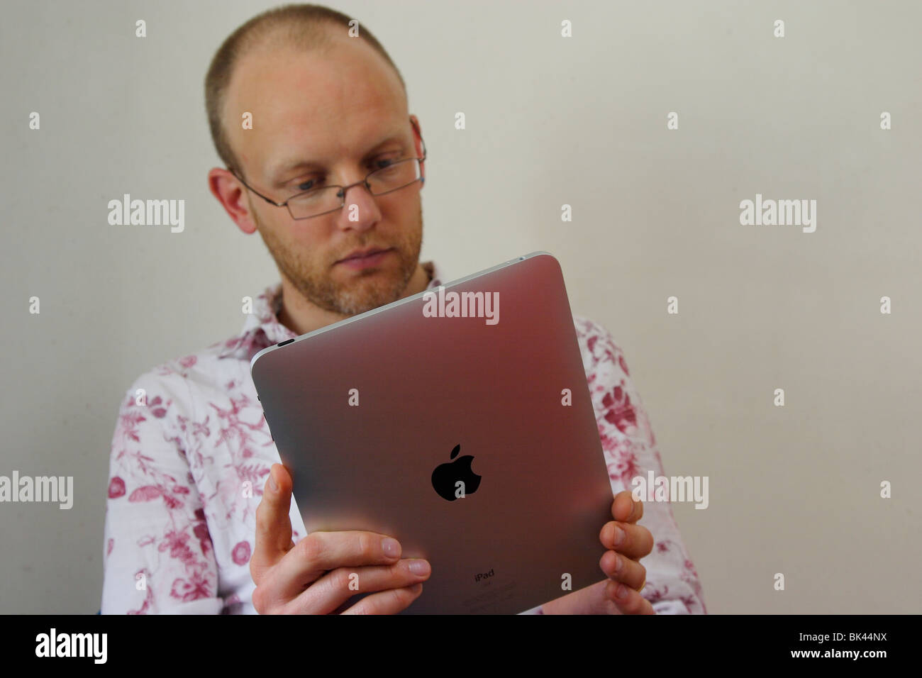 caucasian white male looking at iPad in front of a white background ...