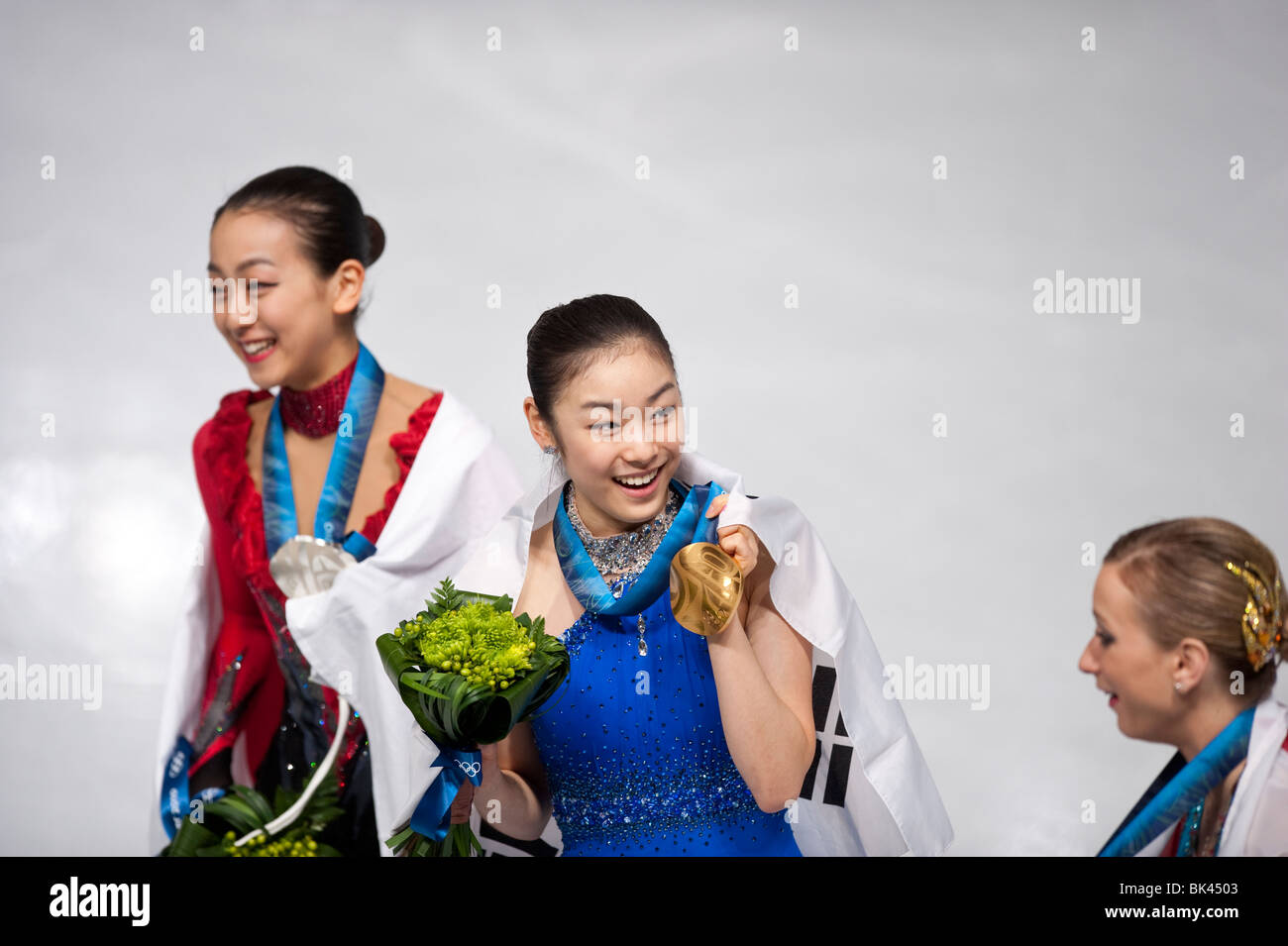 Kim Yu-Na (KOR), Mao Asada (JPN) and Joannie Rochette (CAN) wrapped in ...
