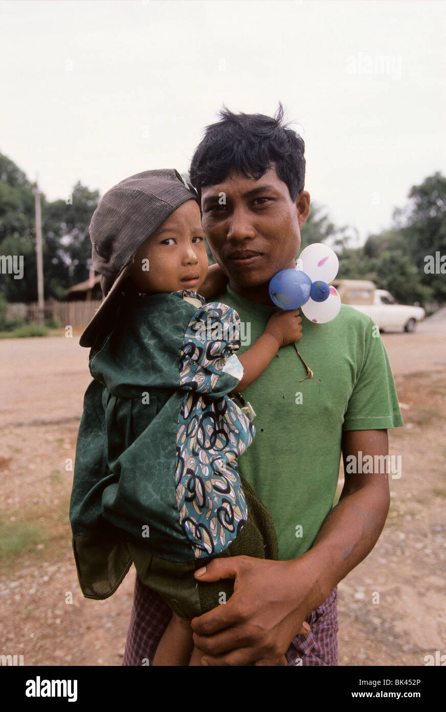 Father holding child with face cream (Thanaka) and ballloons in Myanmar ...