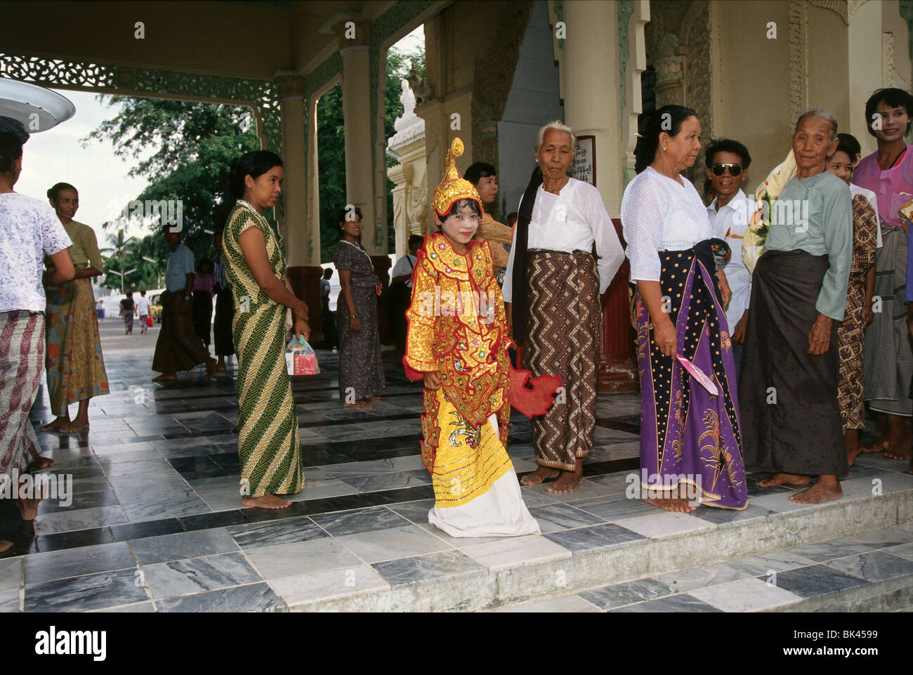 A bejeweled boy in silk garments prepares for monk initiation into the ...