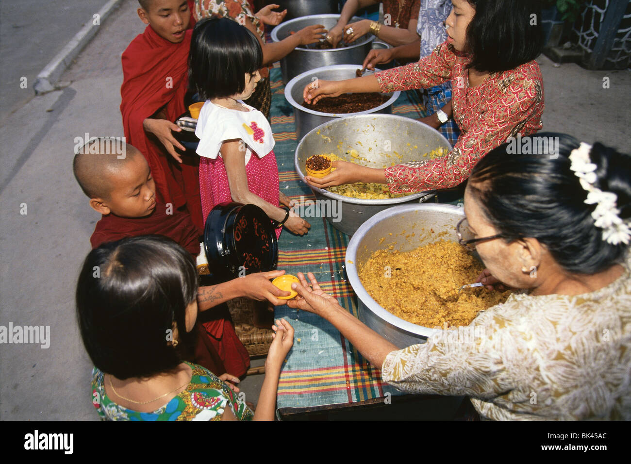 People serving food to young Buddhist monks, Bagan, Mayanmar Stock ...