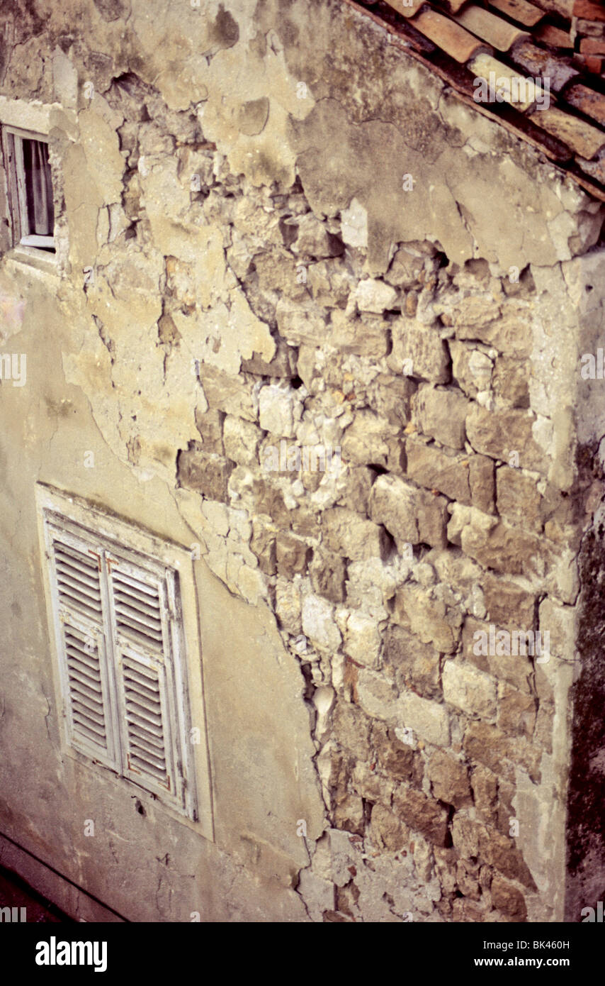 Decayed plaster and exposed stone walls of a multistory dwelling in ...