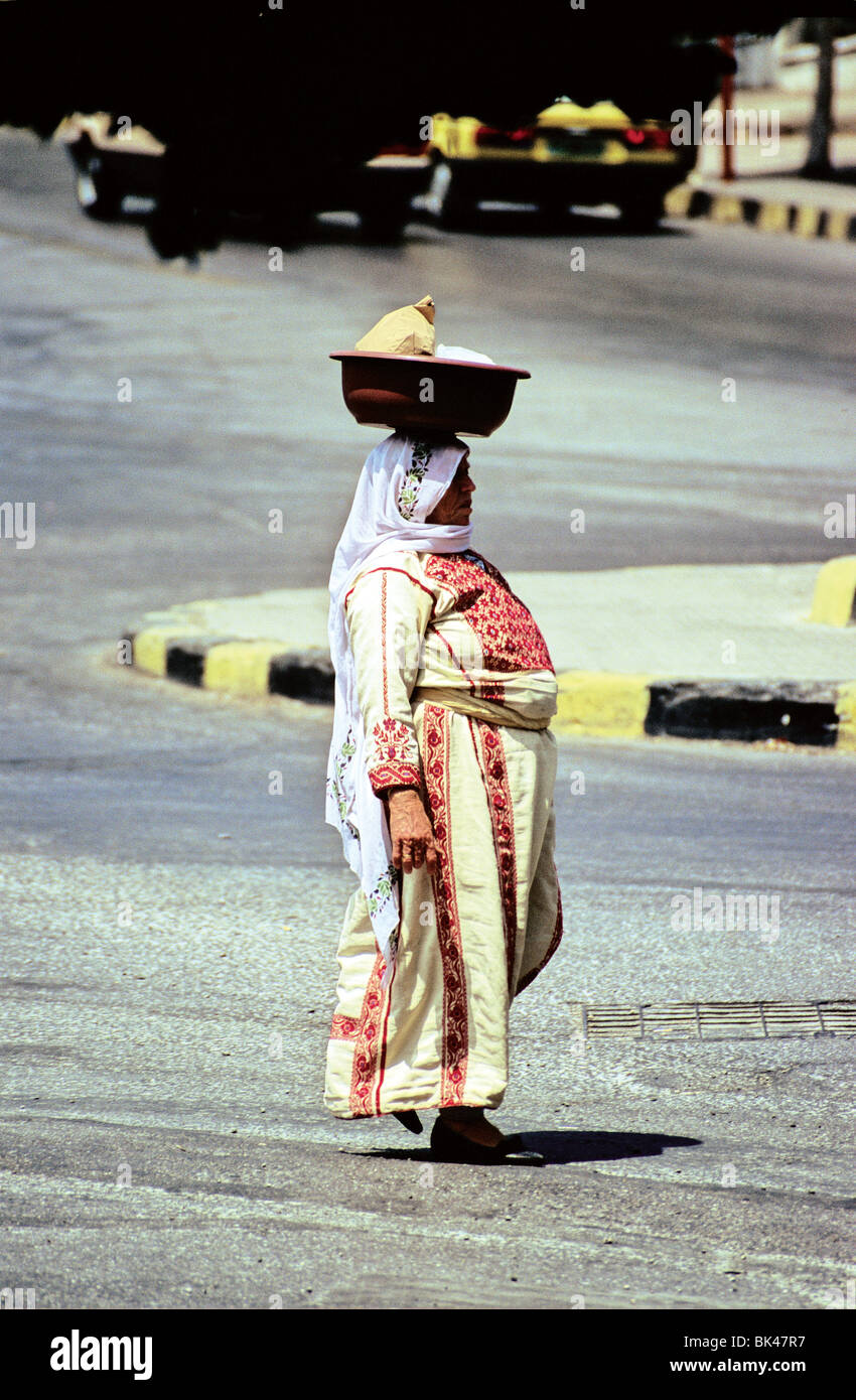 Full-length portrait of a woman walking in the street, Amman, Jordan ...