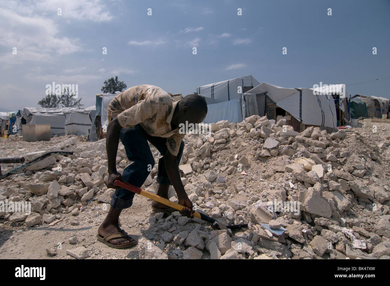 A man removing rubble of a damaged building in a makeshift compound in ...