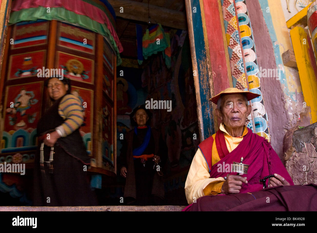Believers circumambulating around a prayer wheel at a Buddhist temple ...