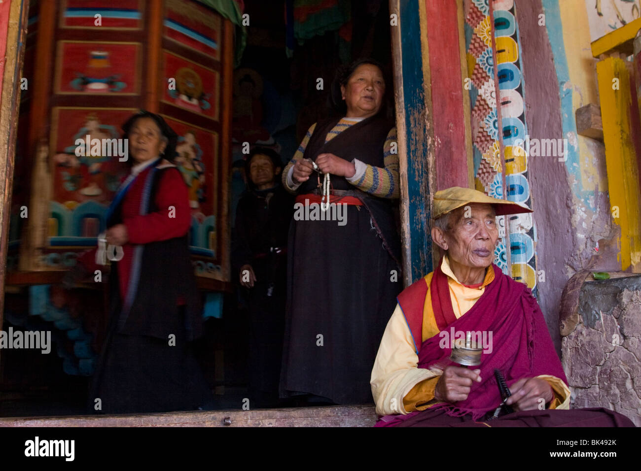 Believers circumambulating around a prayer wheel at a Buddhist temple ...