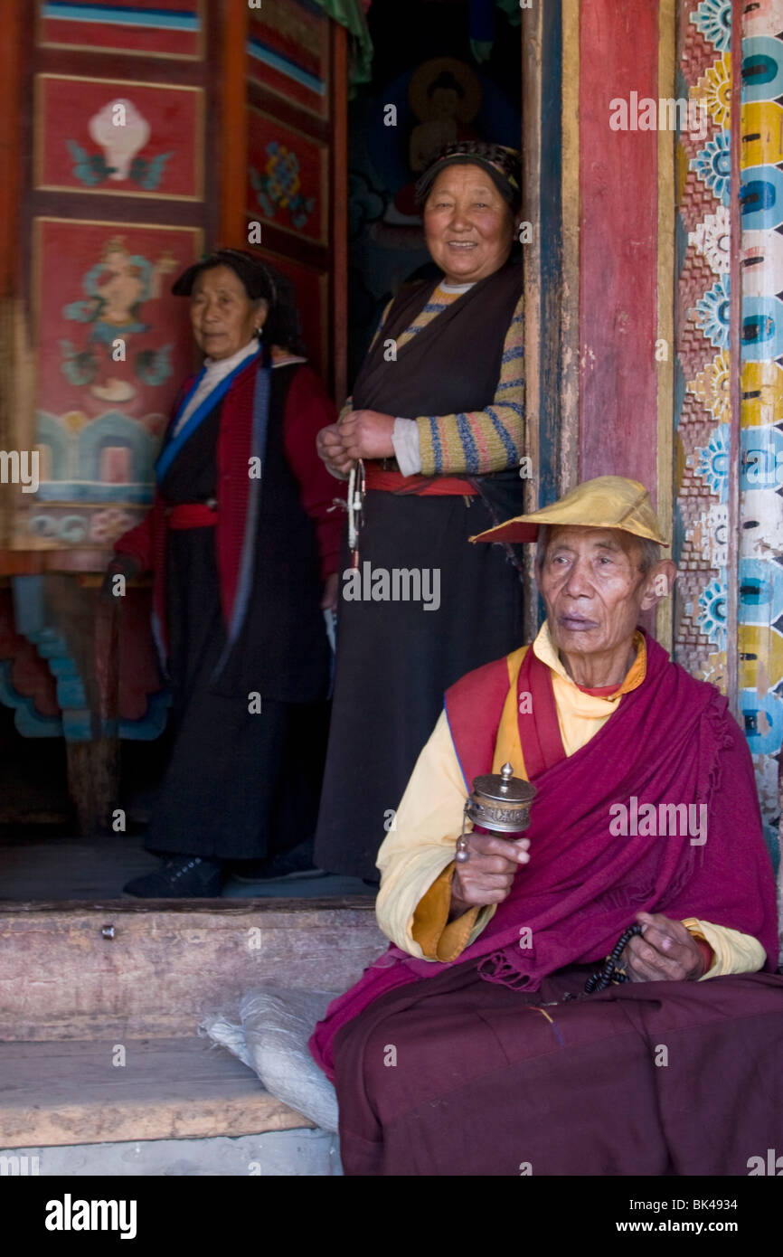 Believers circumambulating around a prayer wheel at a Buddhist temple ...