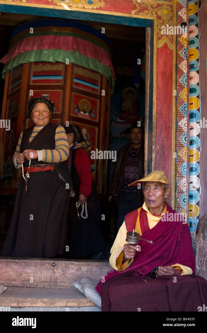 Believers circumambulating around a prayer wheel at a Buddhist temple ...