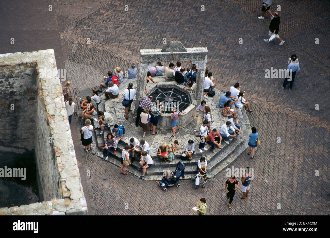 Tourists gathering around the well in the Piazza della Cisterna, San ...