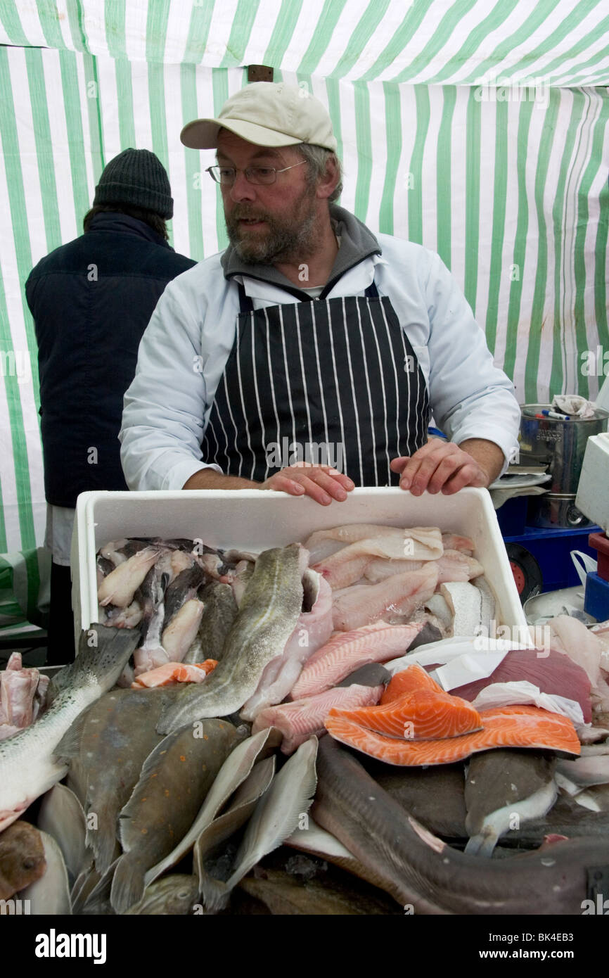 Fishmonger with with a well stocked stall of Fresh fish for sale at ...