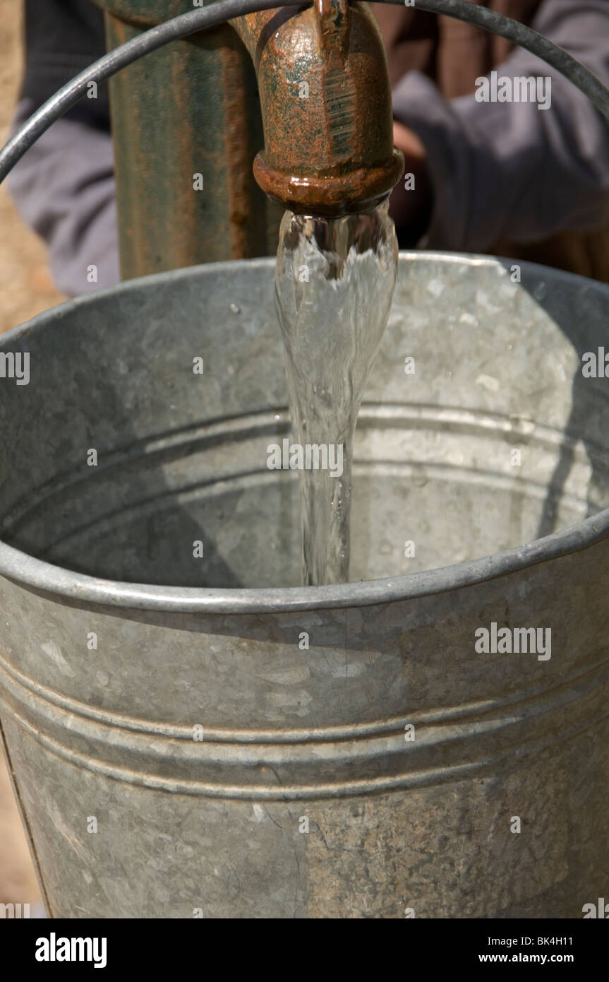 Water being pumped into a metal bucket Stock Photo - Alamy
