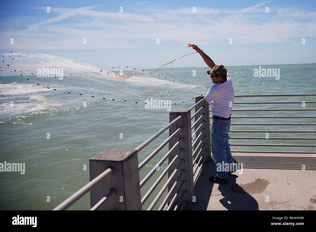 FISHERMAN THROWING OUT BAIT NET FROM PIER SALTWATER FISHING Stock Photo ...