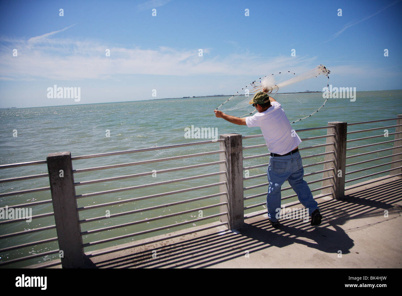 FISHERMAN THROWING OUT BAIT NET FROM PIER SALTWATER FISHING Stock Photo ...