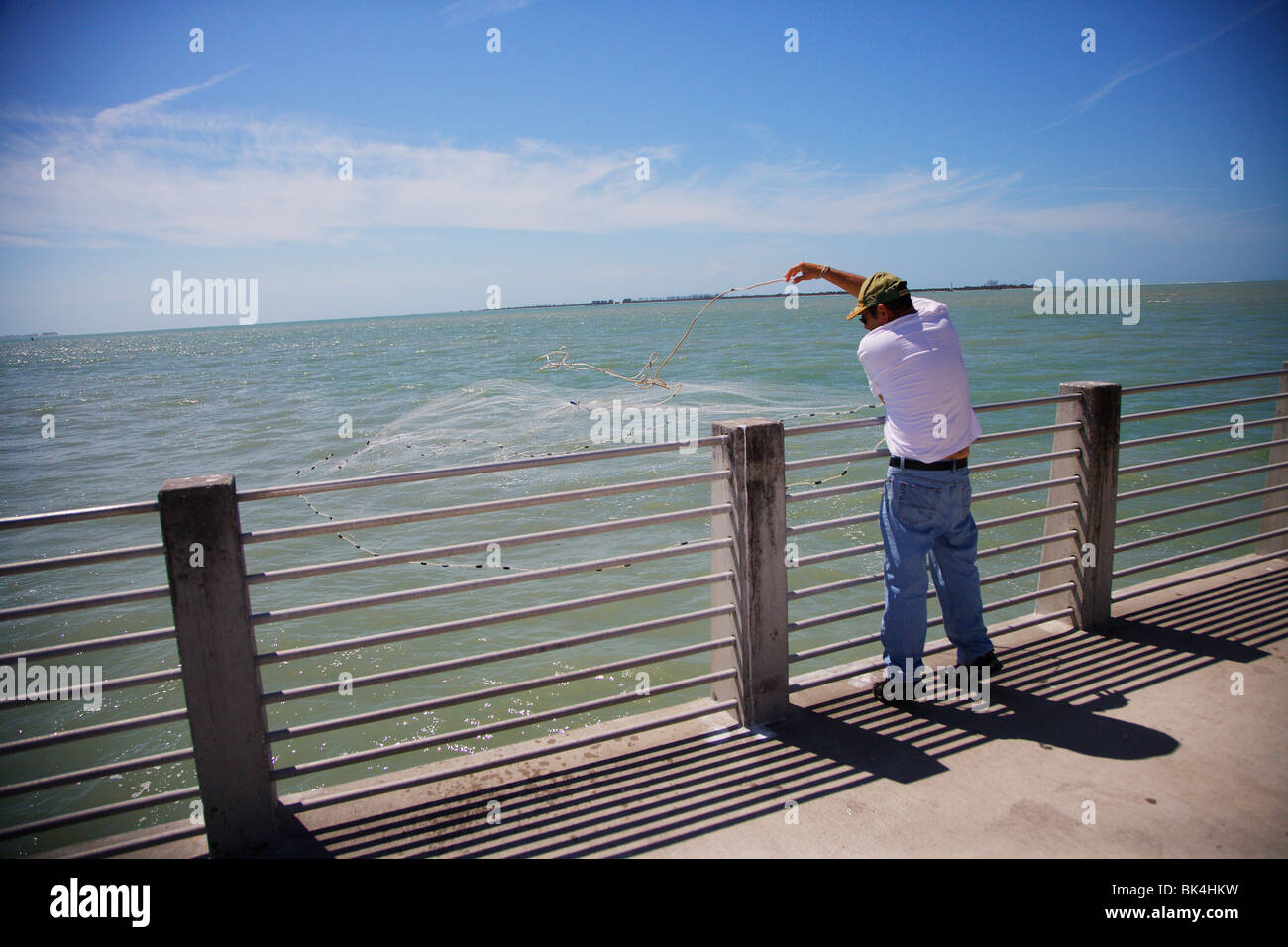 FISHERMAN THROWING OUT BAIT NET FROM PIER SALTWATER FISHING Stock Photo ...