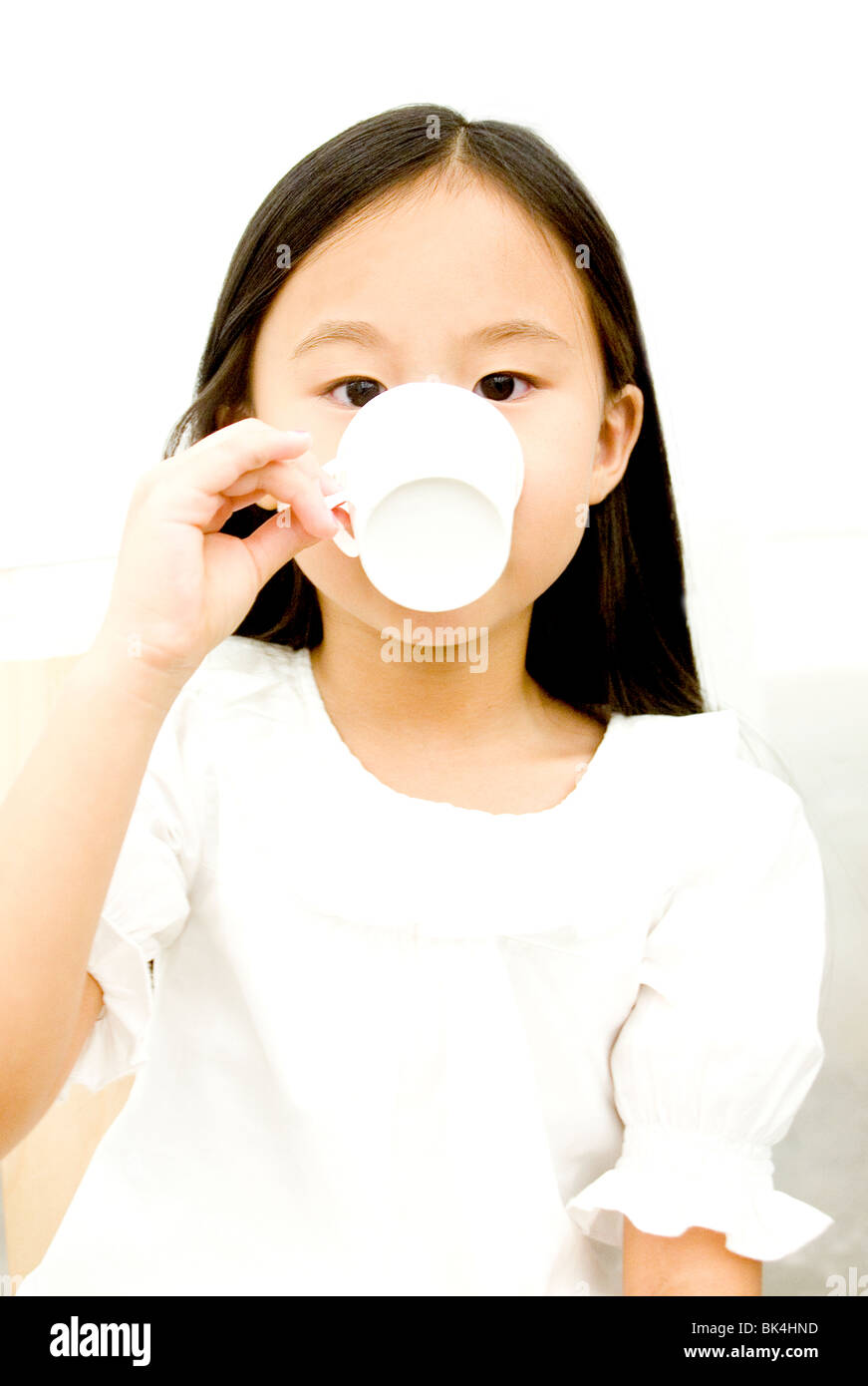 Young asian girl sipping from a tea cup Stock Photo - Alamy