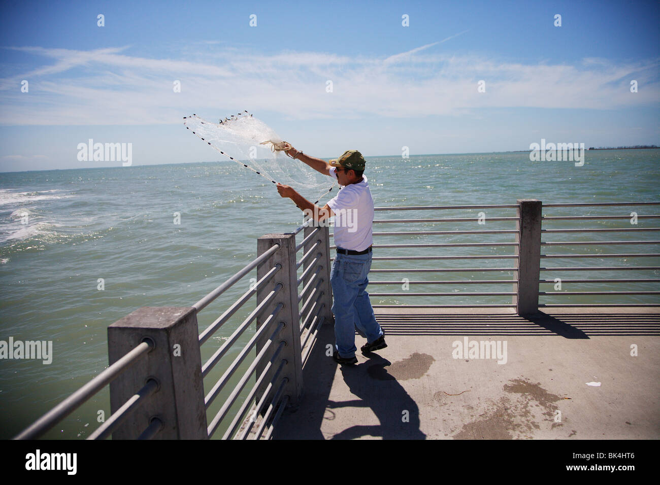 FISHERMAN THROWING OUT BAIT NET FROM PIER SALTWATER FISHING Stock Photo ...