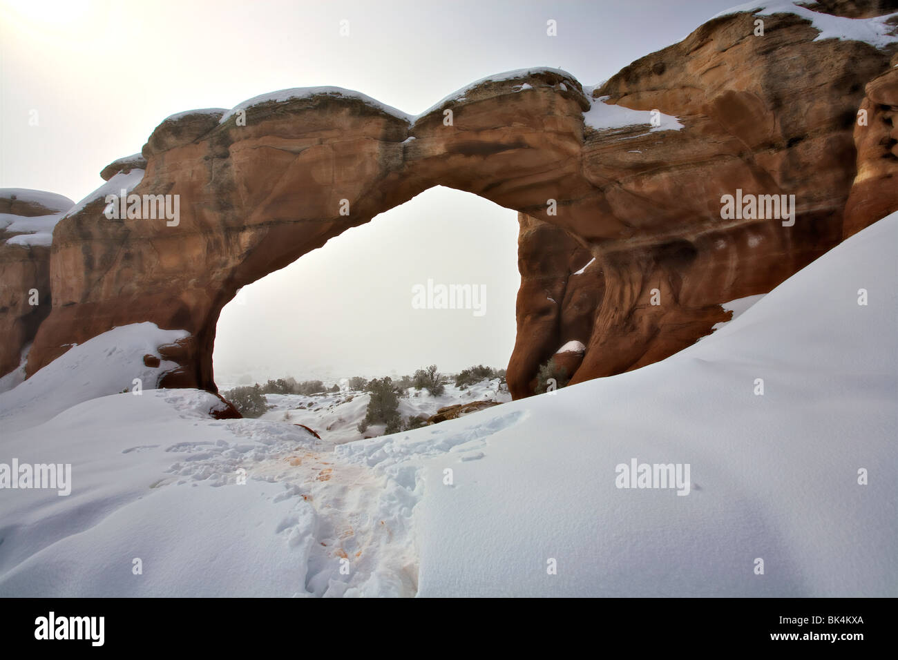 Broken Arch at Arches National Park, Utah. Snow and fog during winter ...