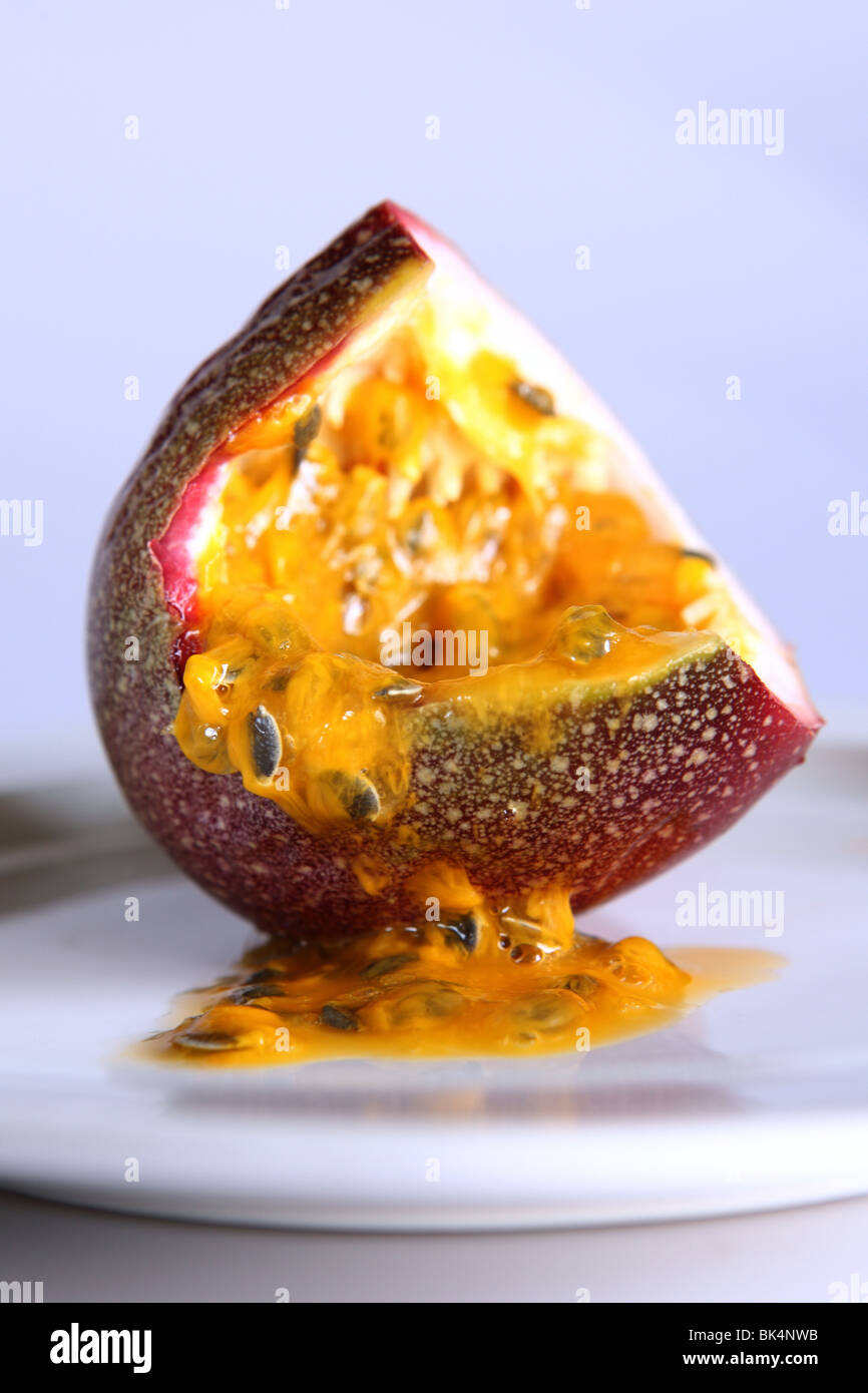Passion fruit cut open on a plate Stock Photo - Alamy