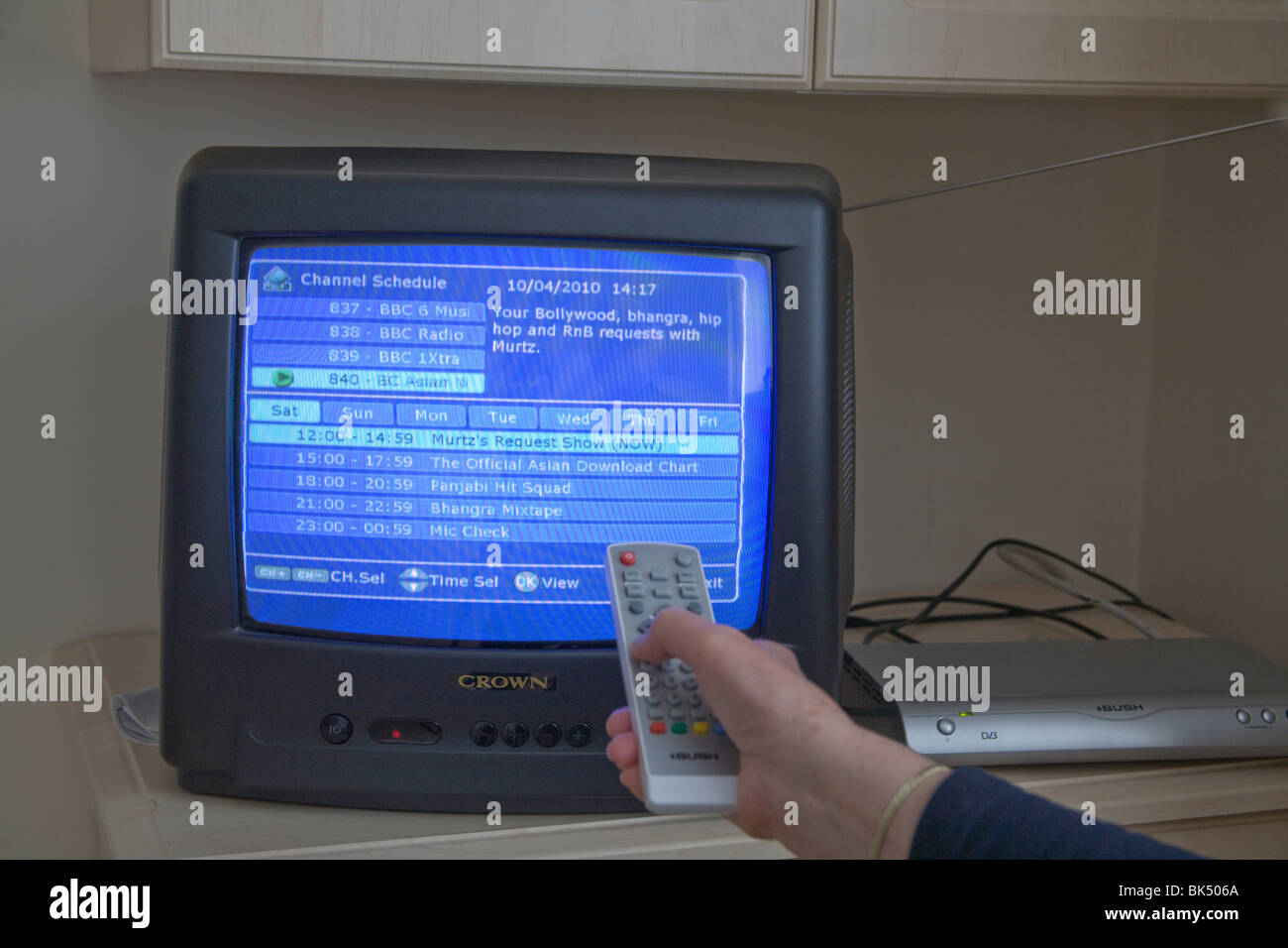 Close up Female senior citizen using a remote control to check the ...