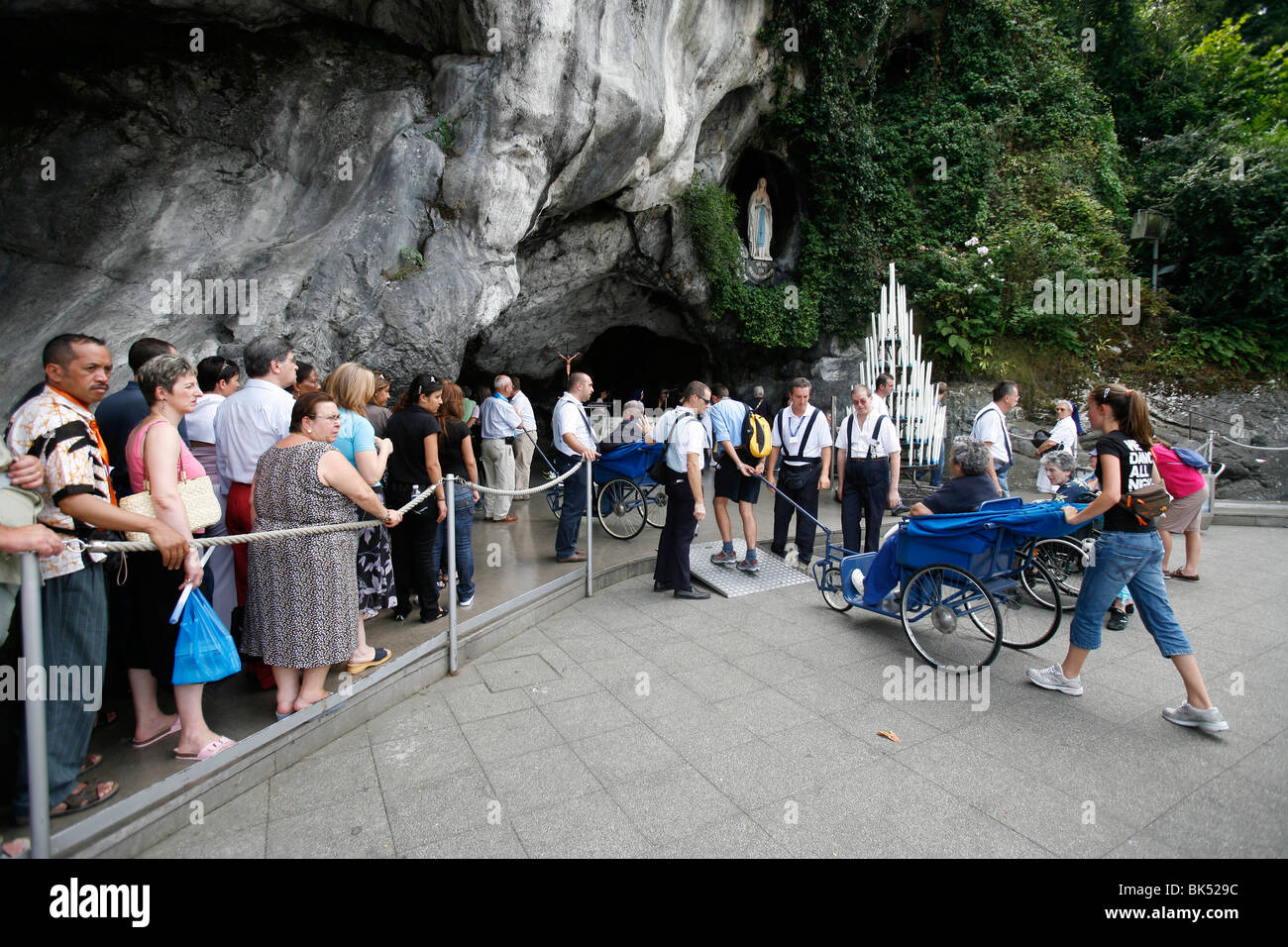 Pilgrims at the Lourdes grotto, Lourdes, Hautes Pyrenees, France ...
