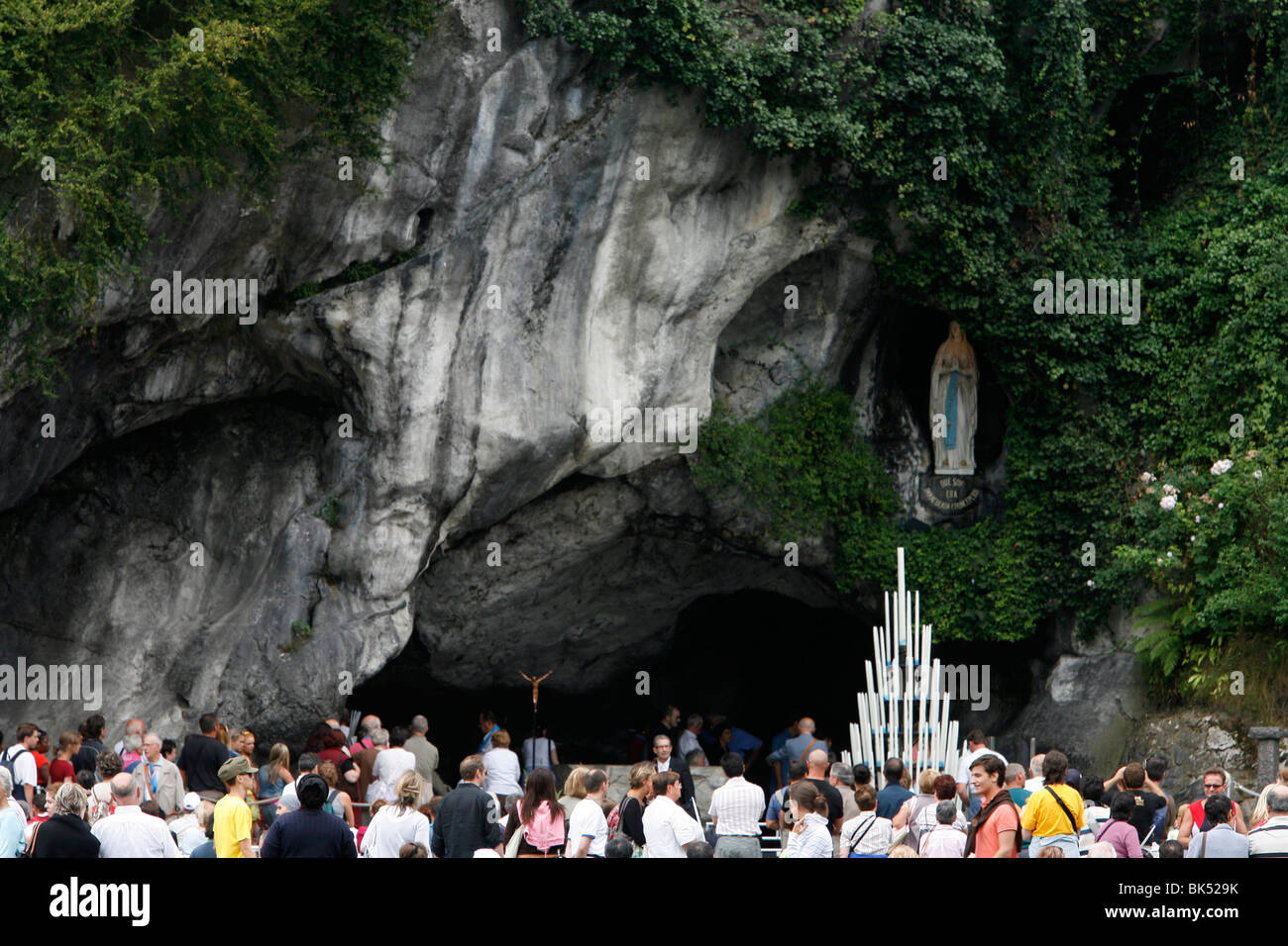 Pilgrim outside the Lourdes grotto, Lourdes, Hautes Pyrenees, France ...