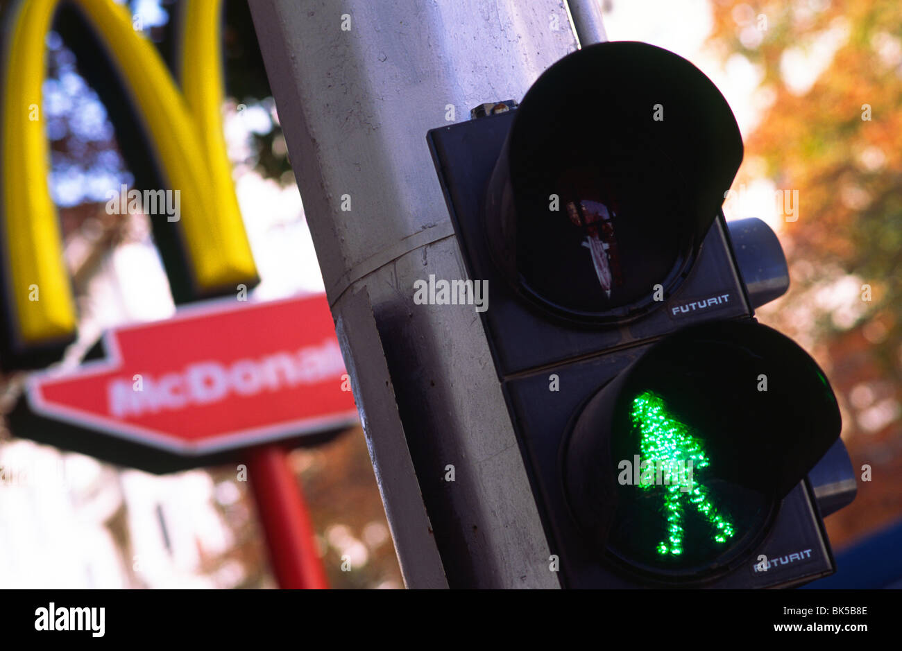 Traffic light gives green or walk signal at a pedestrian crossing in ...