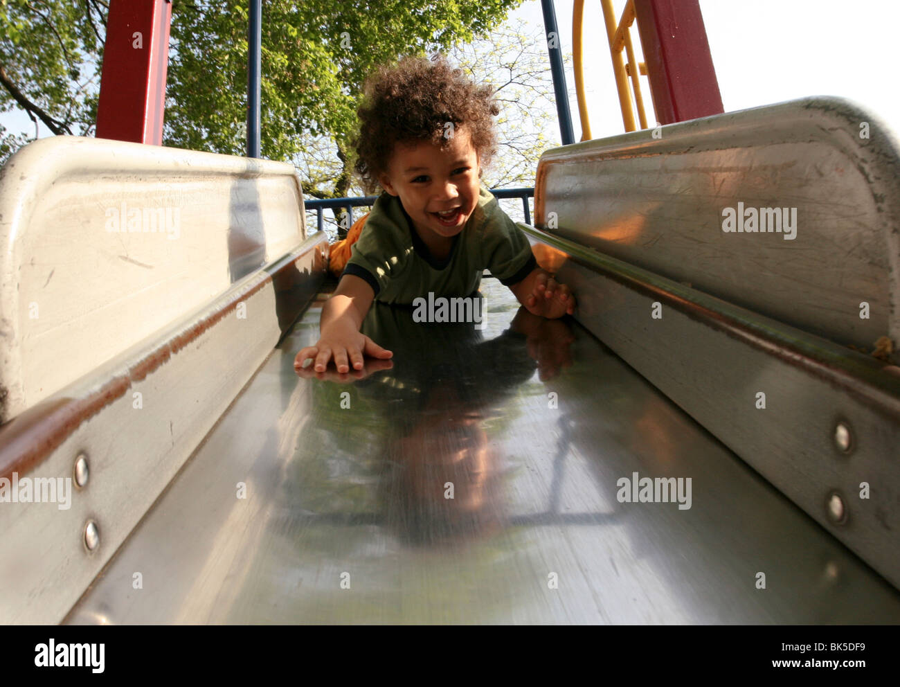 Boy playing on a slide Stock Photo - Alamy