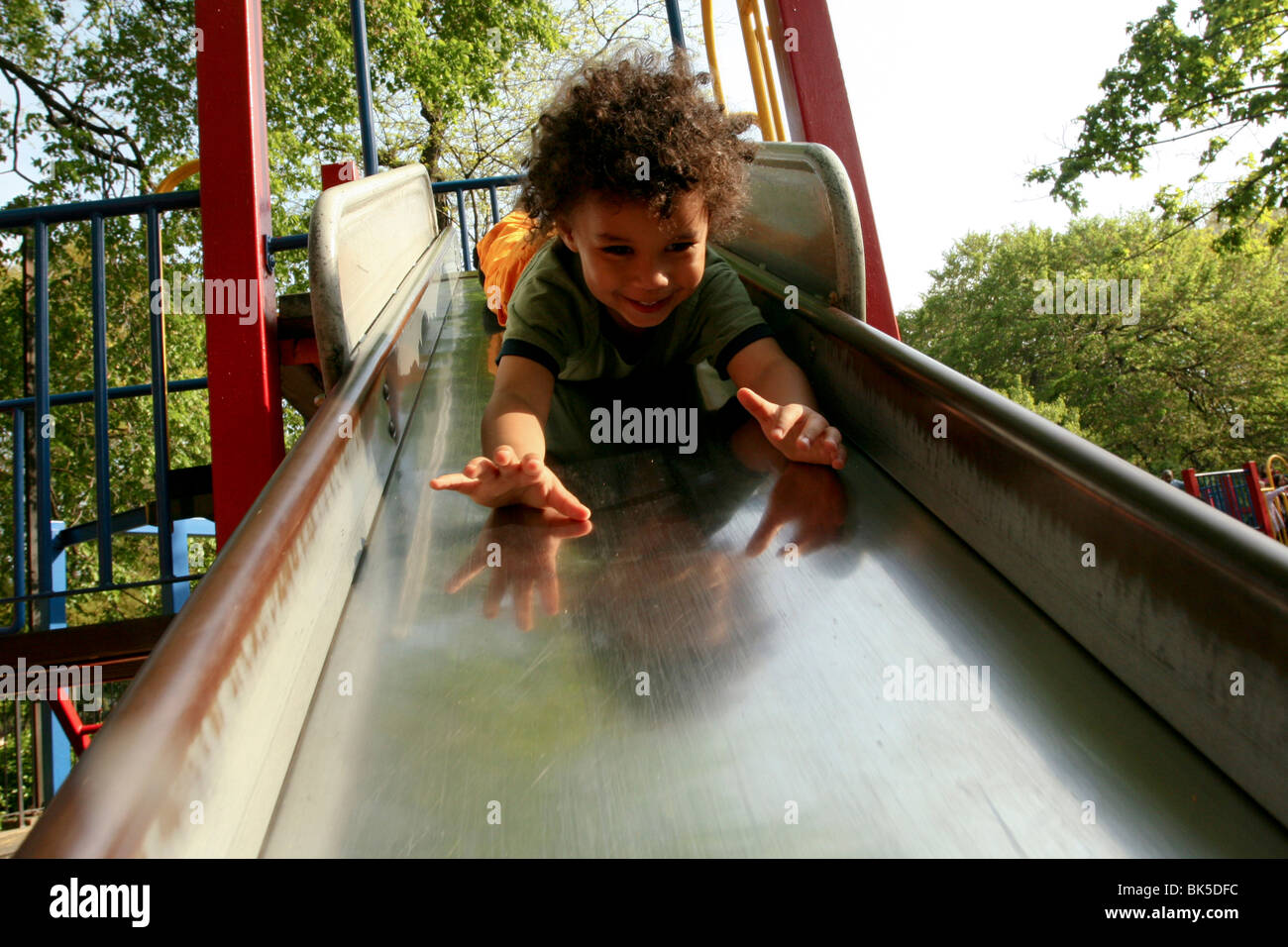 Boy playing on a slide Stock Photo - Alamy