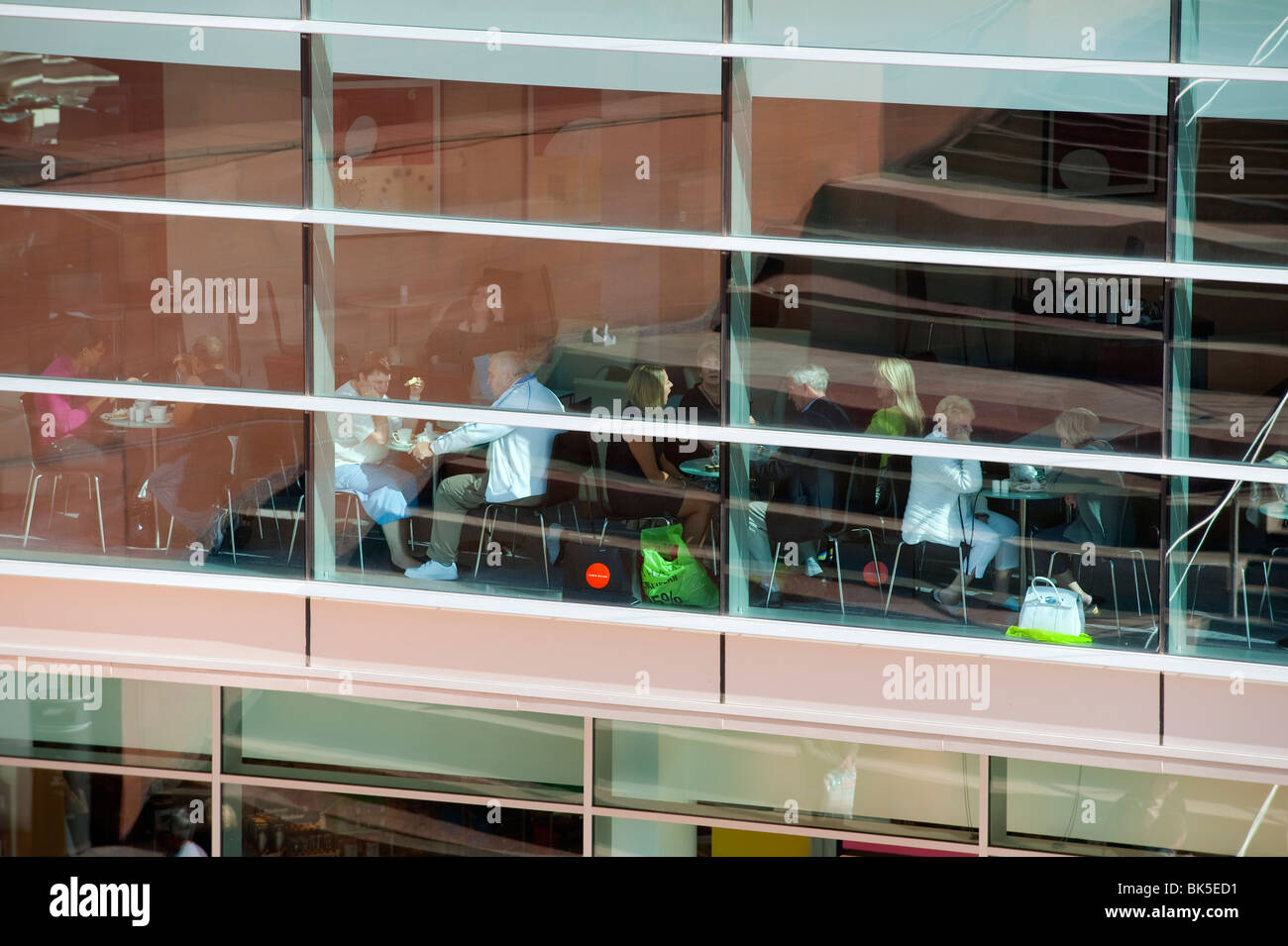 Reflections of shoppers in department store cafe Liverpool One shopping ...