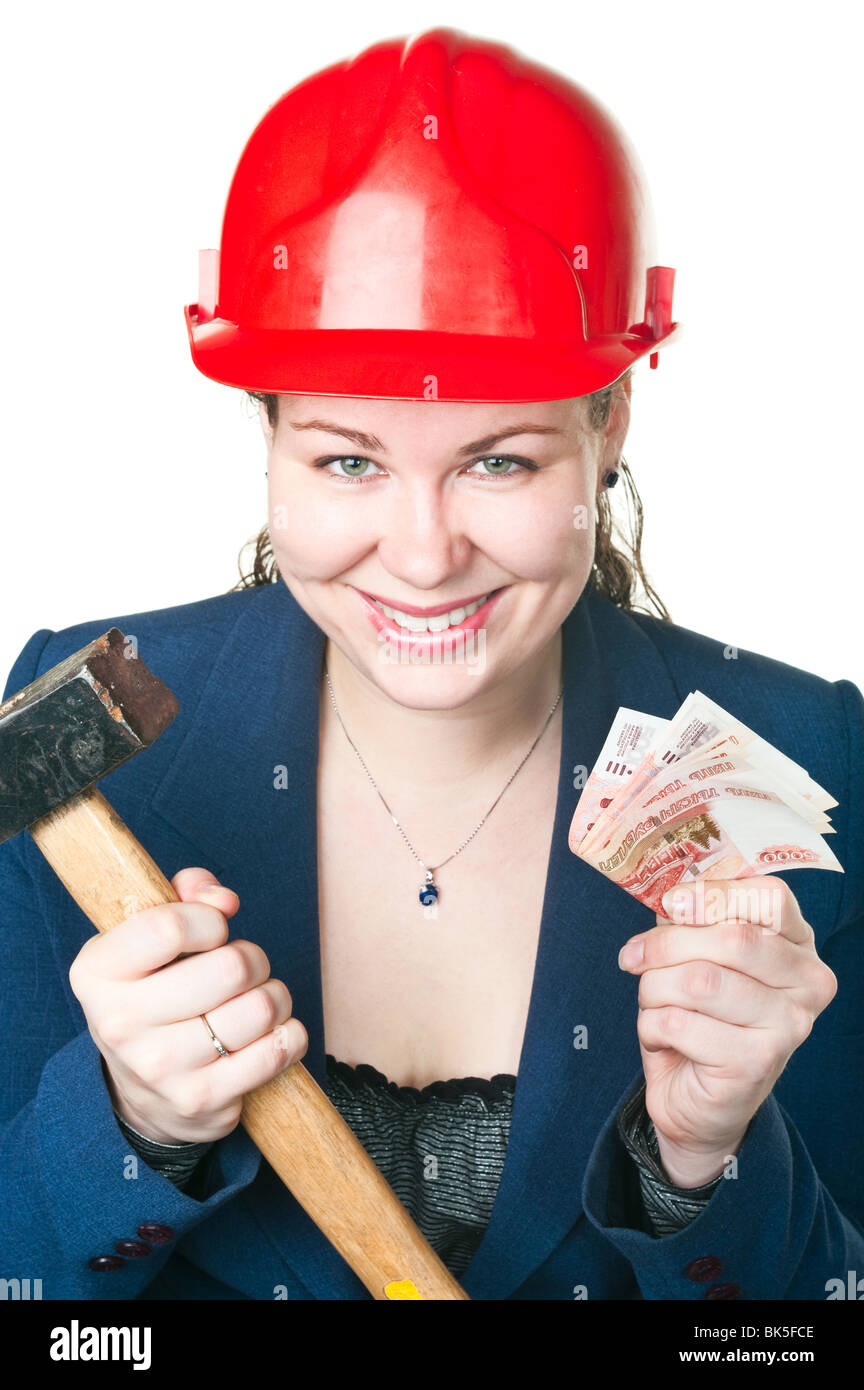 The girl in a building helmet with a hammer and cash in hands. It is ...