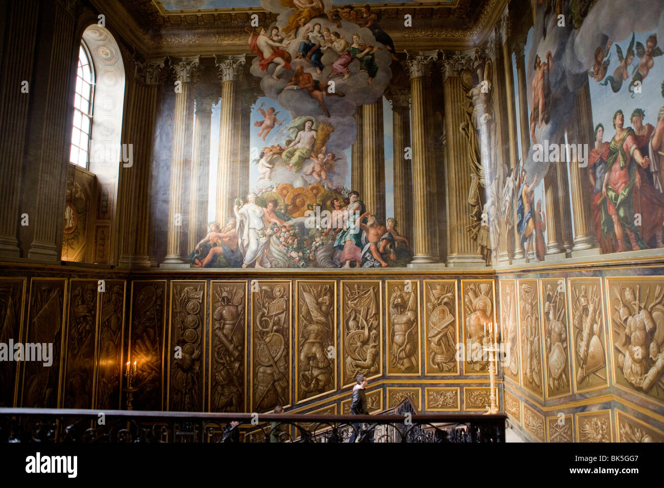 A stairway decorated with ornate paintings inside Hampton Court Palace ...