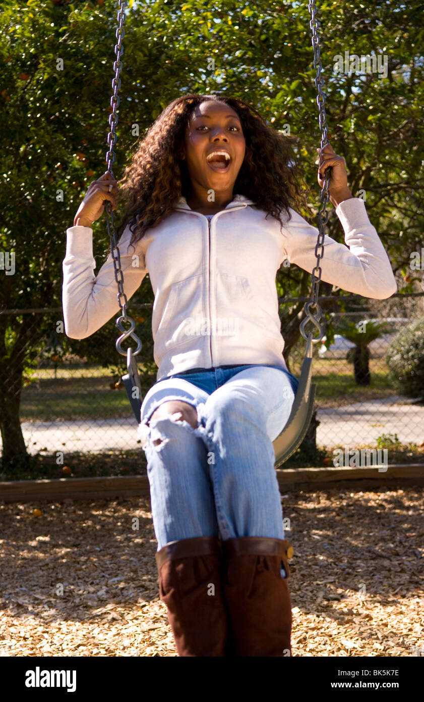 Black african american woman relaxing on swing in park laughing ...
