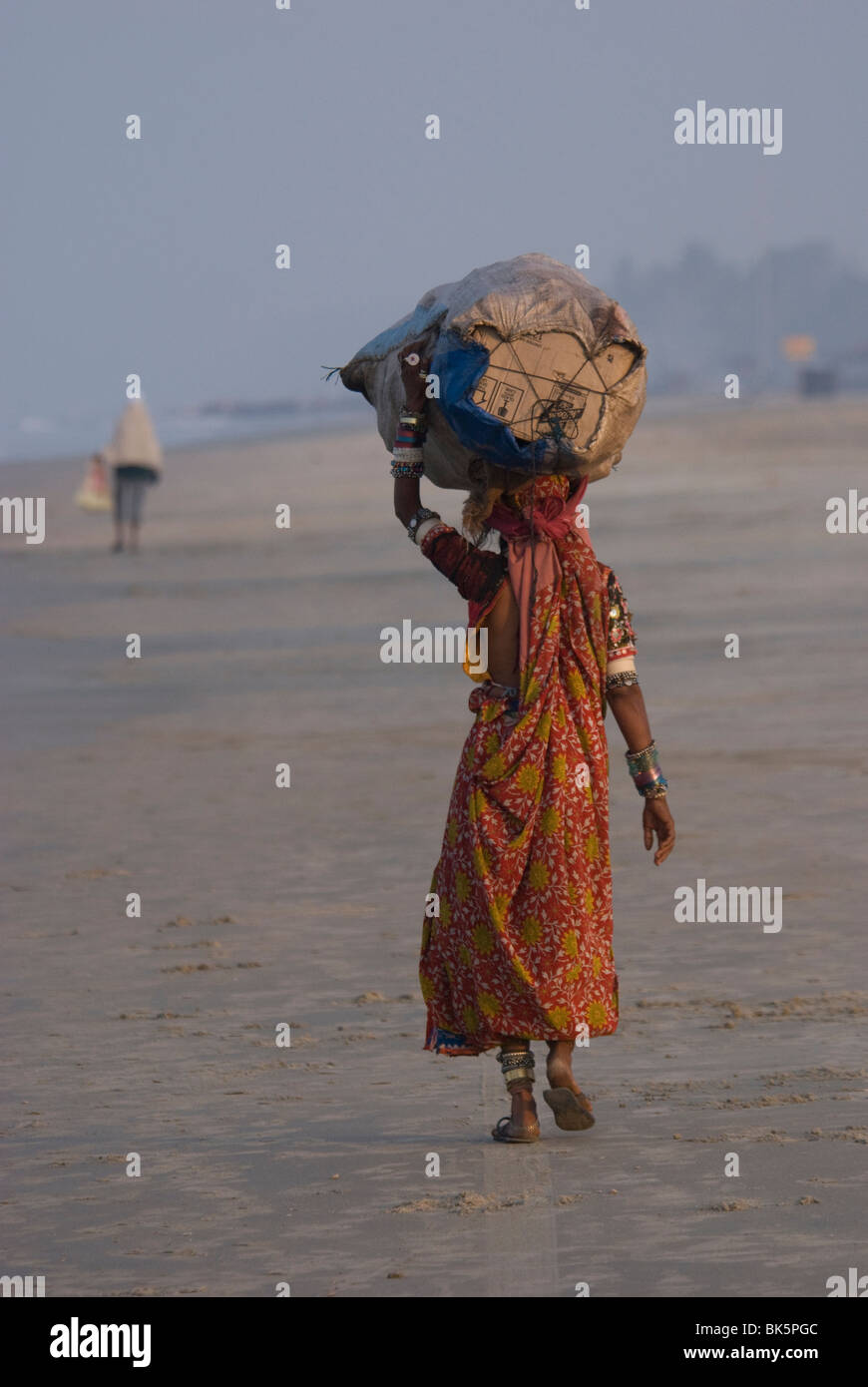 Woman carrying a sack on her head, Colva Beach, Goa, India Stock Photo ...