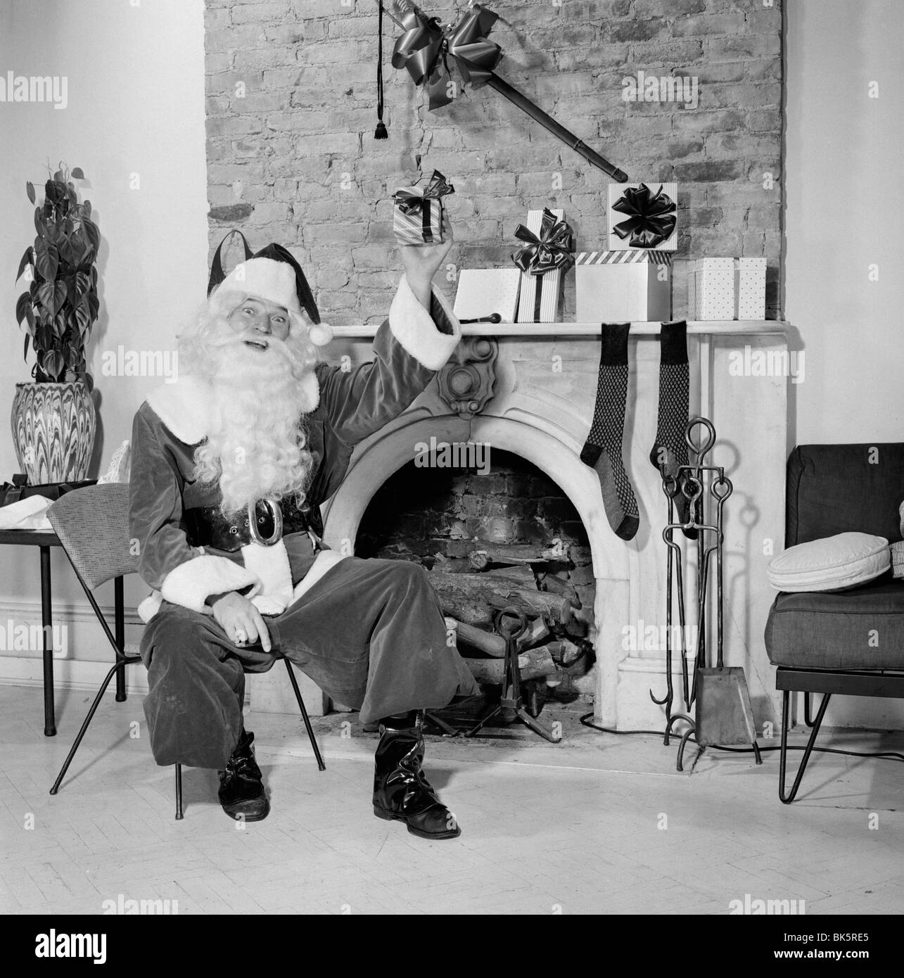 Santa claus in front fireplace Black and White Stock Photos & Images ...