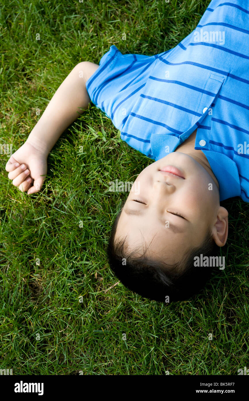 Boy lying on the grass Stock Photo - Alamy