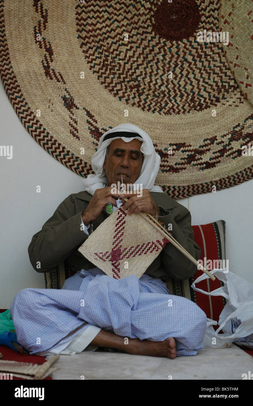Elderly Arabian man sitting on the floor and weaving a mat Stock Photo ...