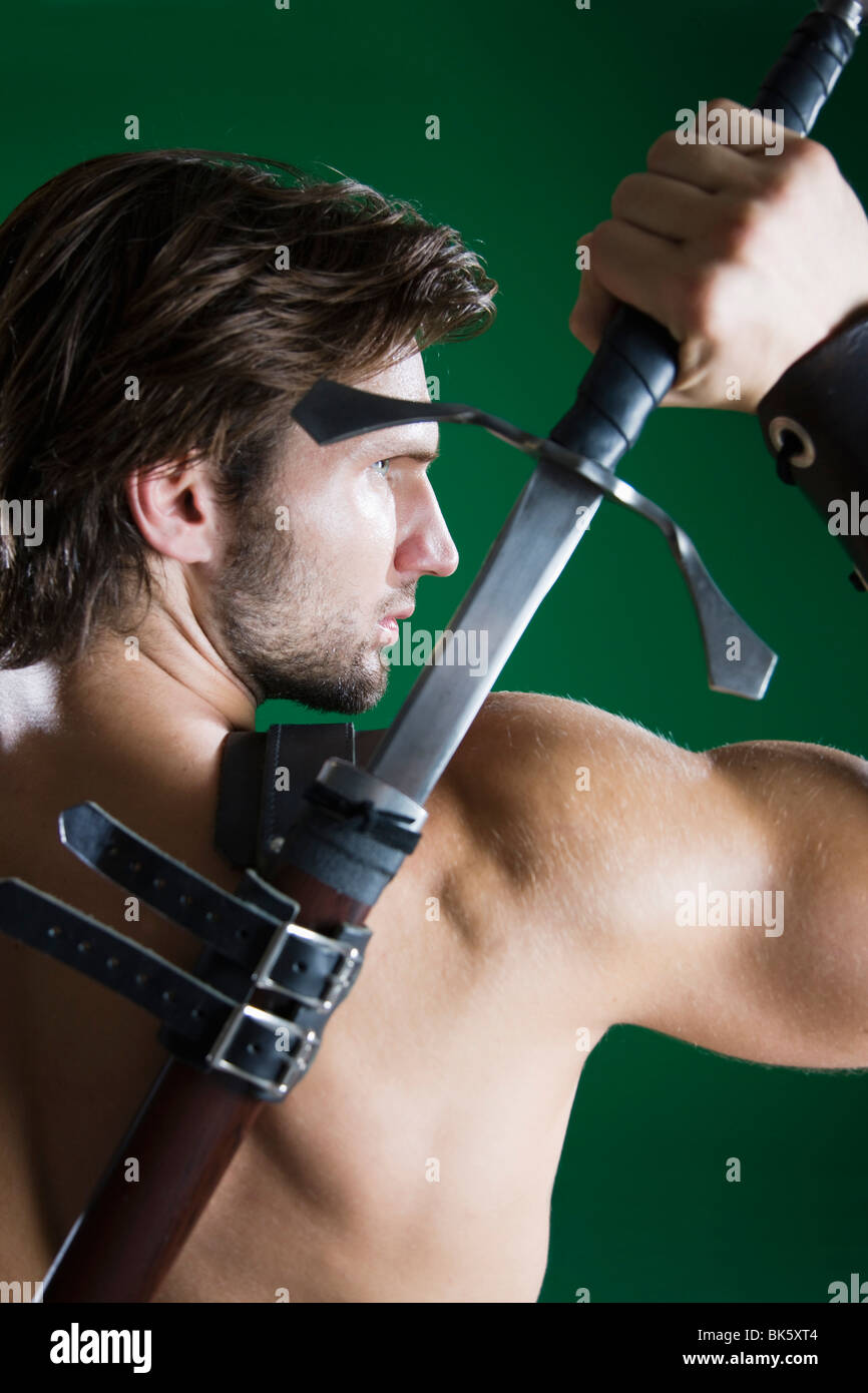 Young man taking out a sword from the sheath Stock Photo - Alamy