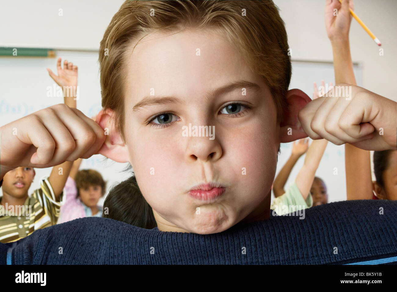 Portrait of a boy making a face in a classroom Stock Photo - Alamy