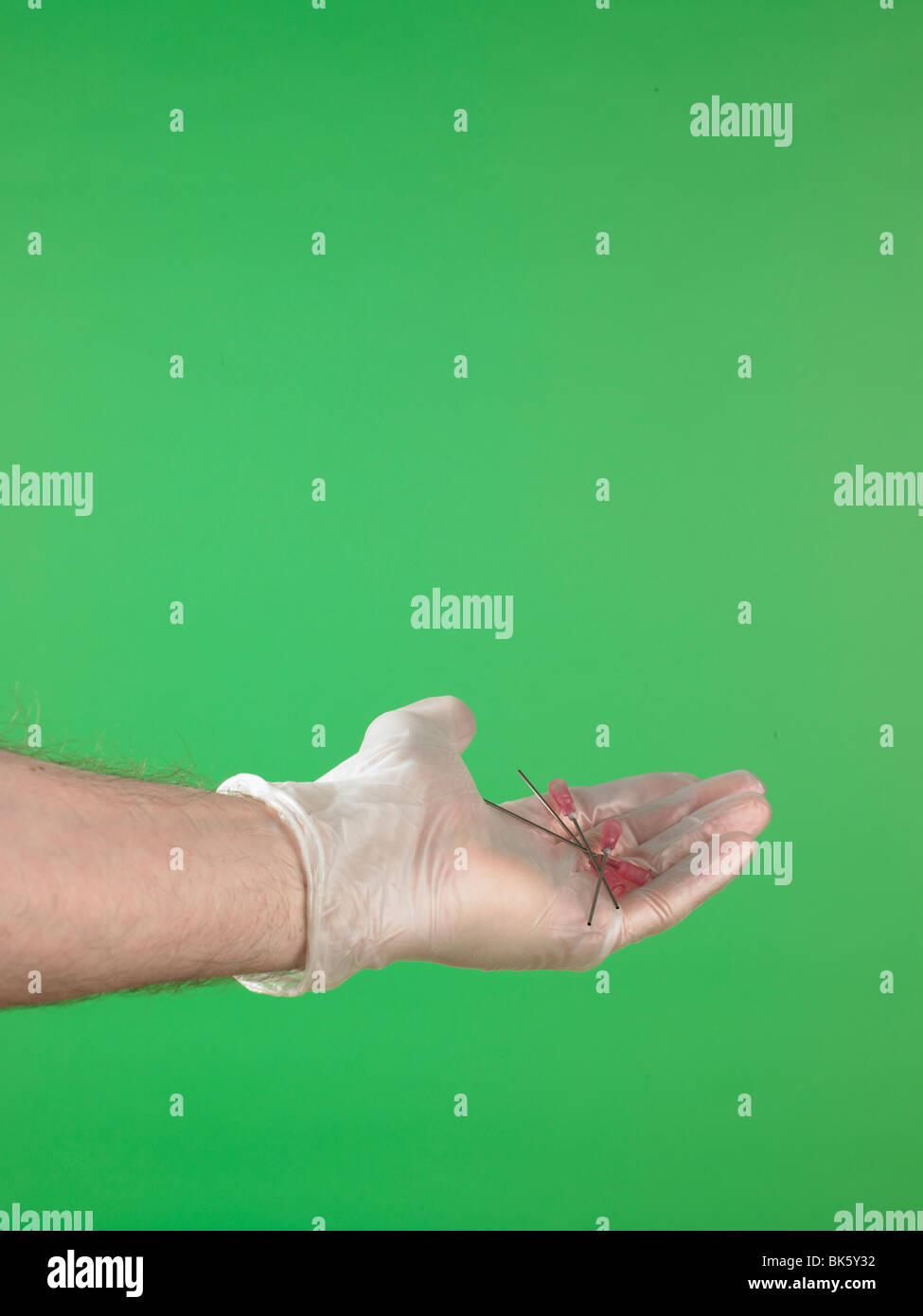 Medical gloved hand with needles in an open hand Stock Photo - Alamy