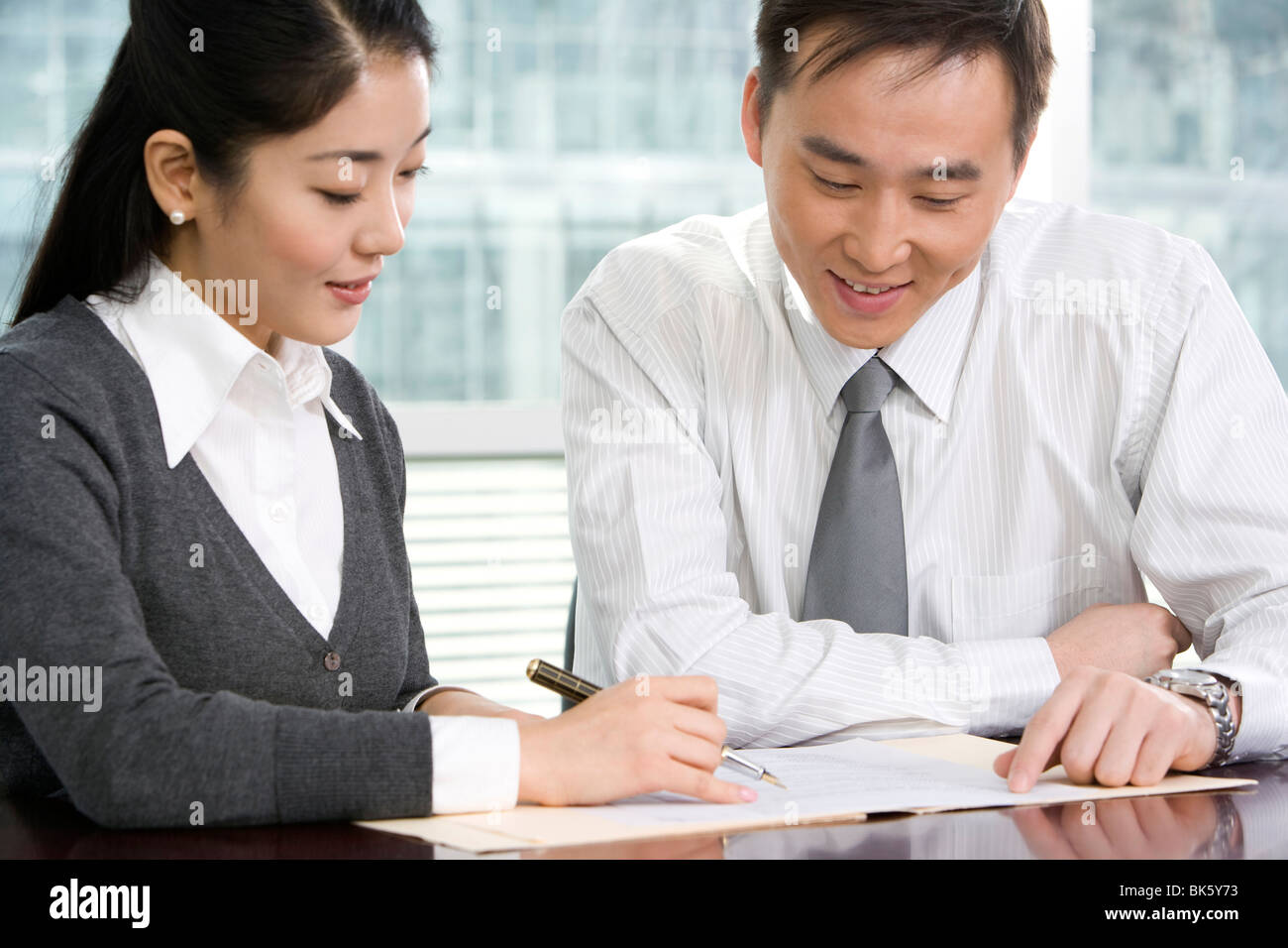 Officemates working together Stock Photo - Alamy