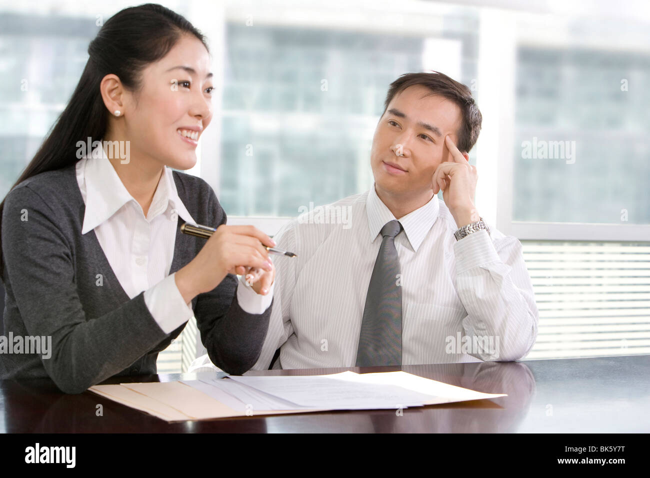 Officemates working together Stock Photo - Alamy