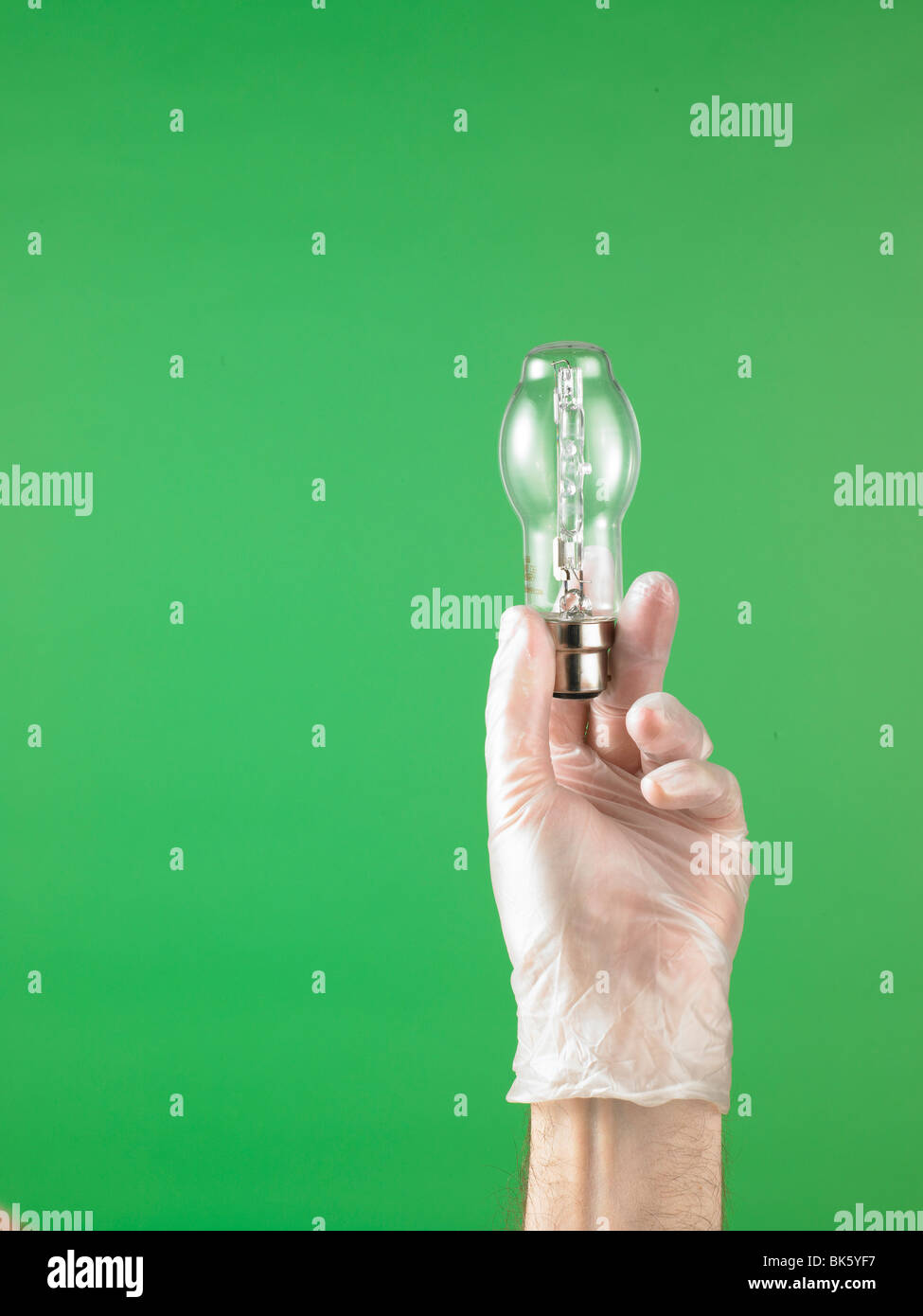 Gloved hand on green with light bulb Stock Photo - Alamy
