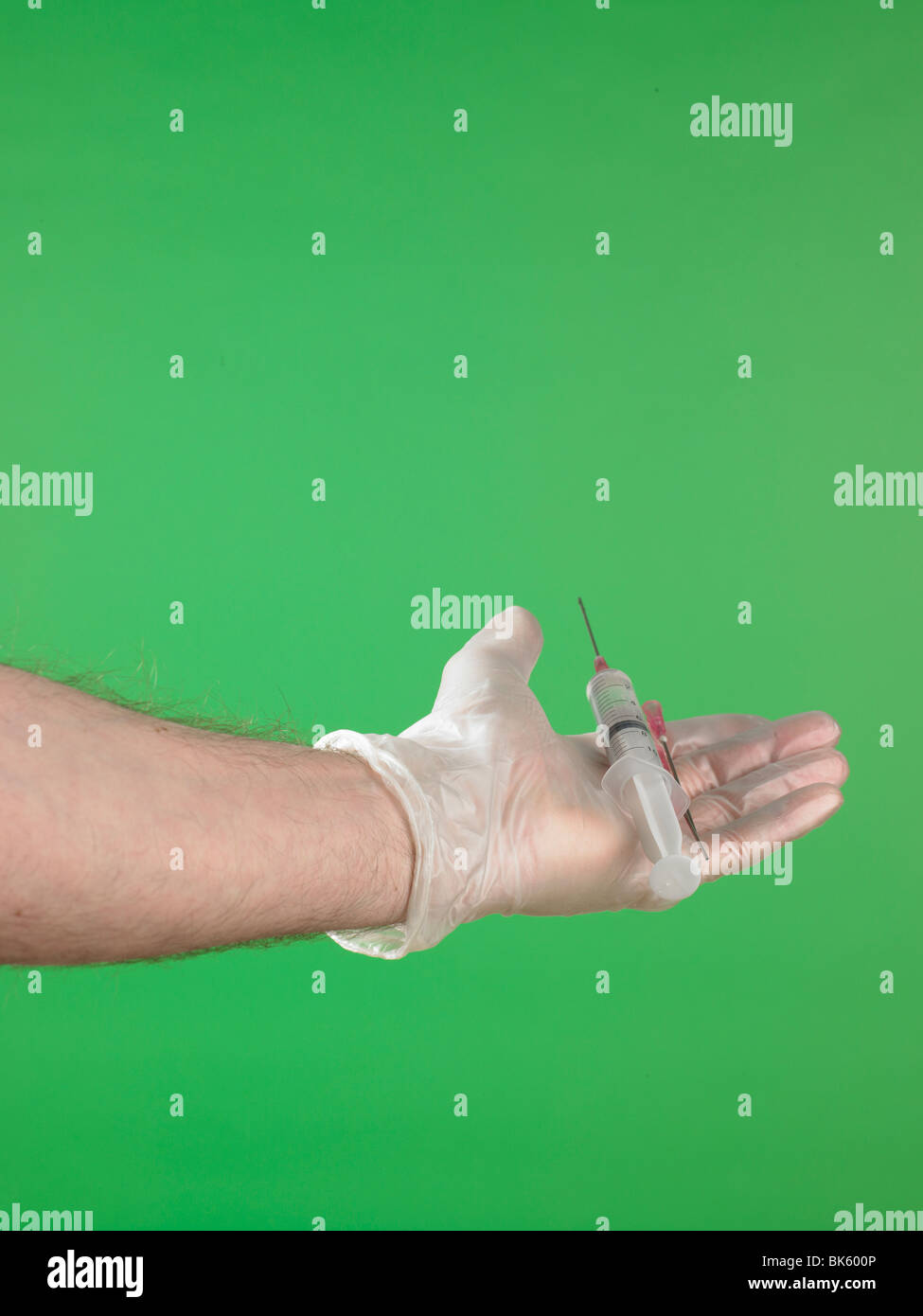 Medical gloved hand with syringe and needles Stock Photo - Alamy