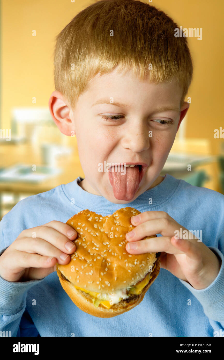 Boy eating a hamburger Stock Photo - Alamy